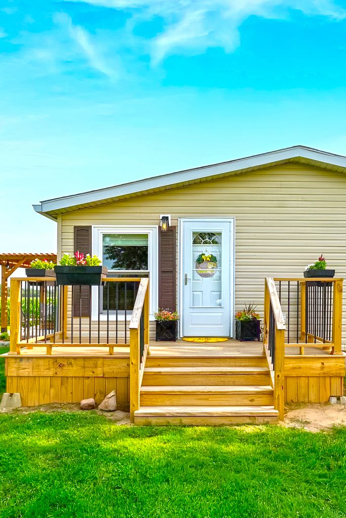 A Stylish Mobile Home Exterior with Front Deck and Back Patio